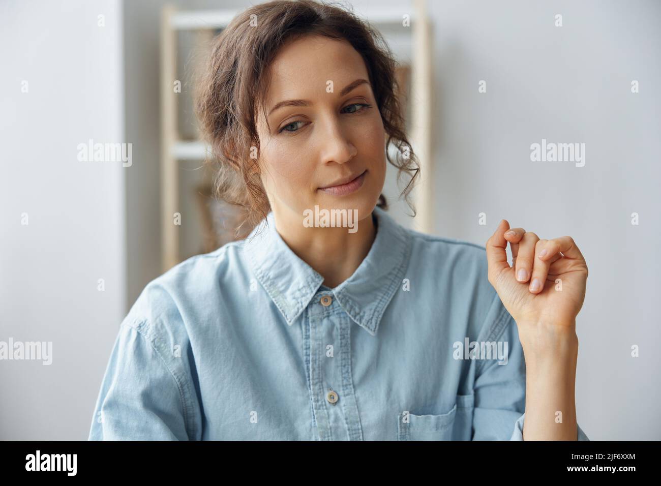 Serious irritated anxious angry curly-haired businesswoman is trying to ...