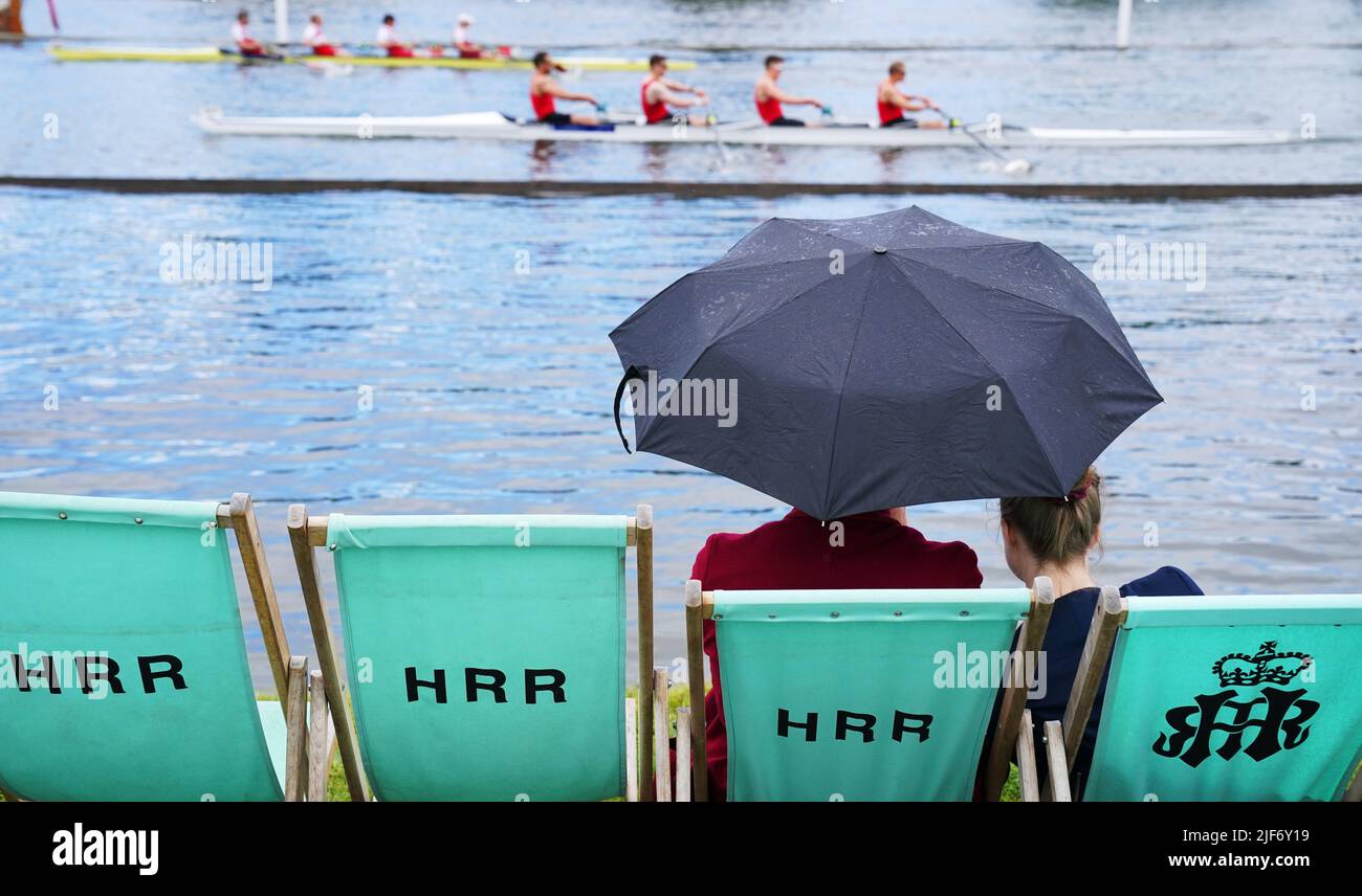 Visitors to the Stewards' Enclosure watch the racing whilst sheltering ...