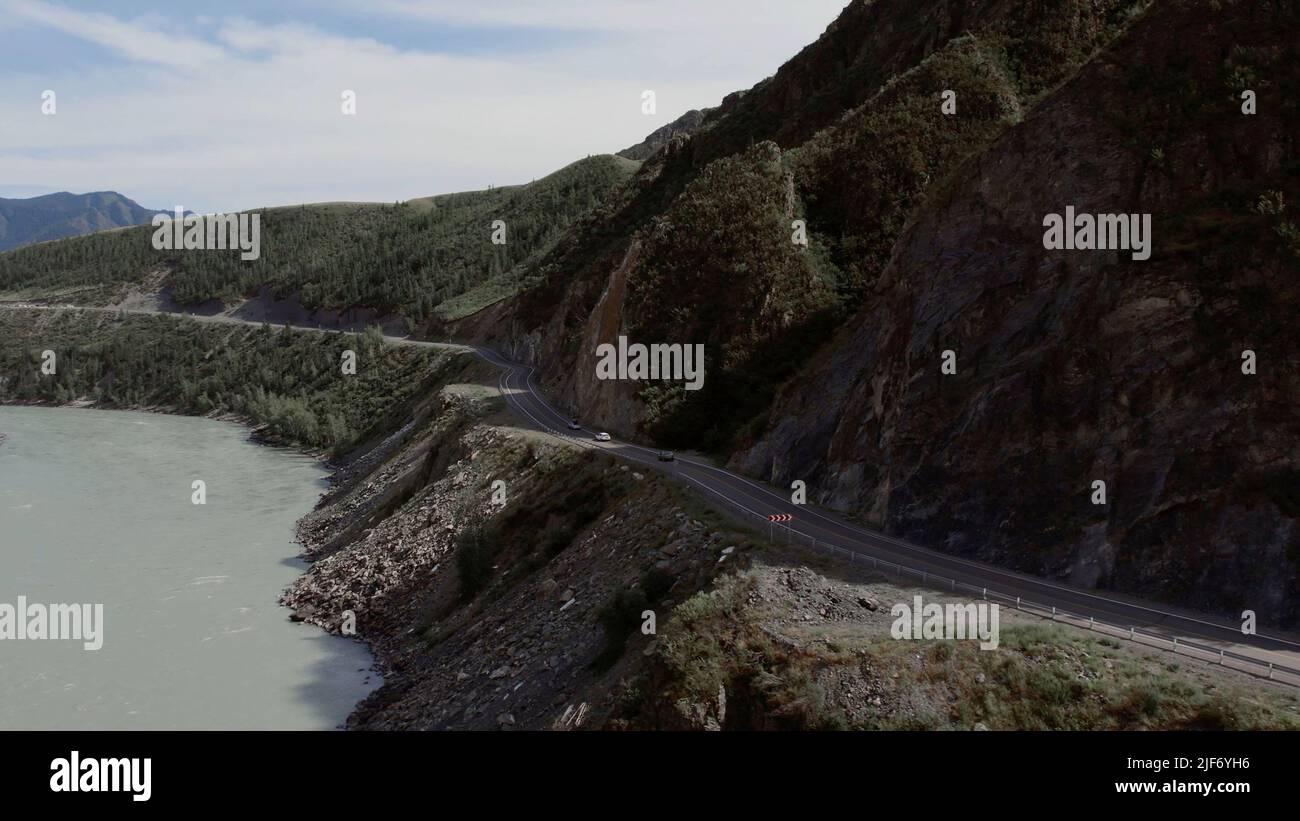 Traffic cars on Chuya highway road between mountains and Katun river in ...
