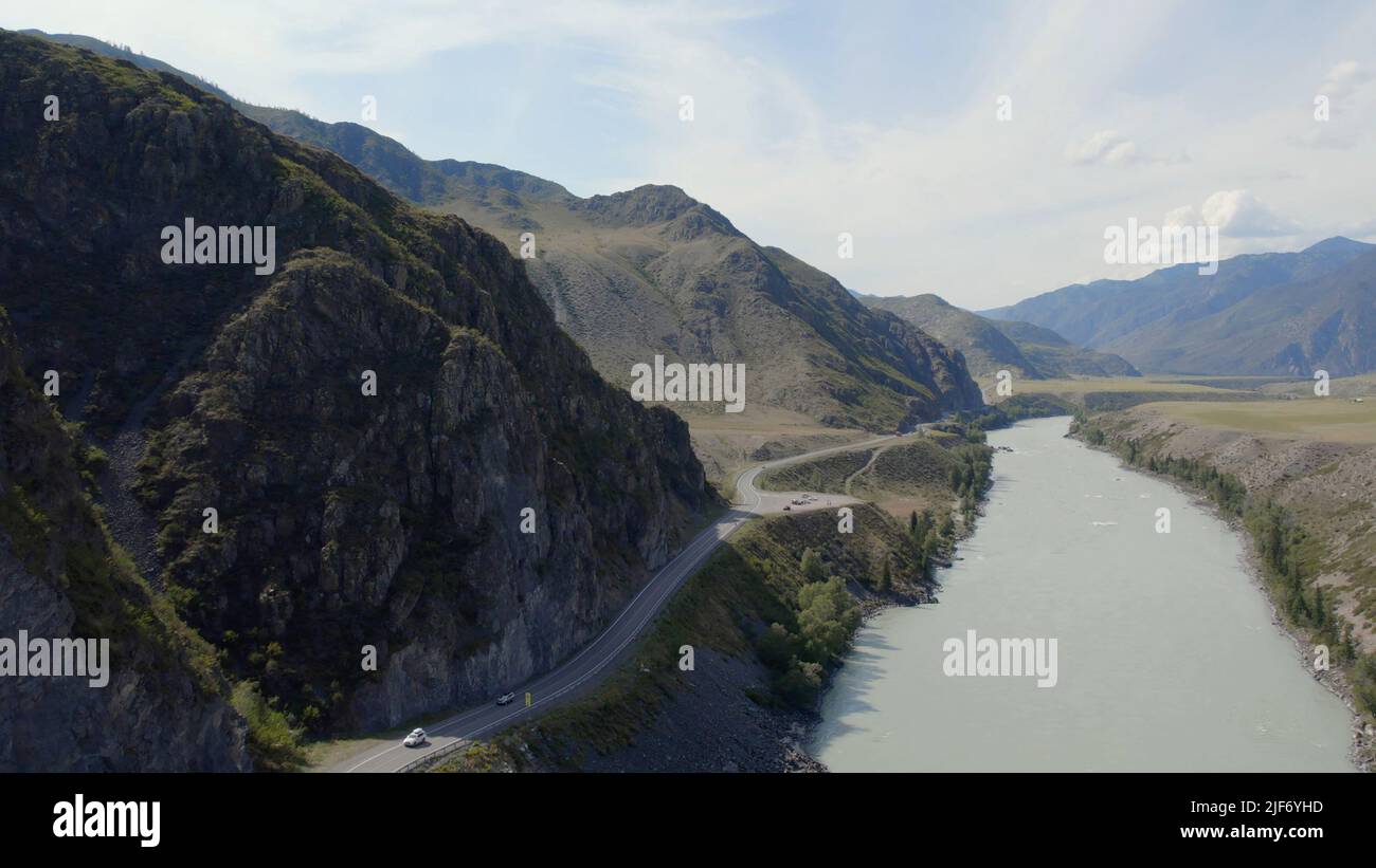 Traffic cars on Chuya highway road between mountains and Katun river ...