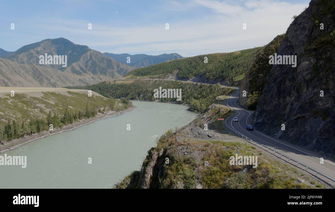Traffic cars on Chuya highway road between mountains and Katun river ...