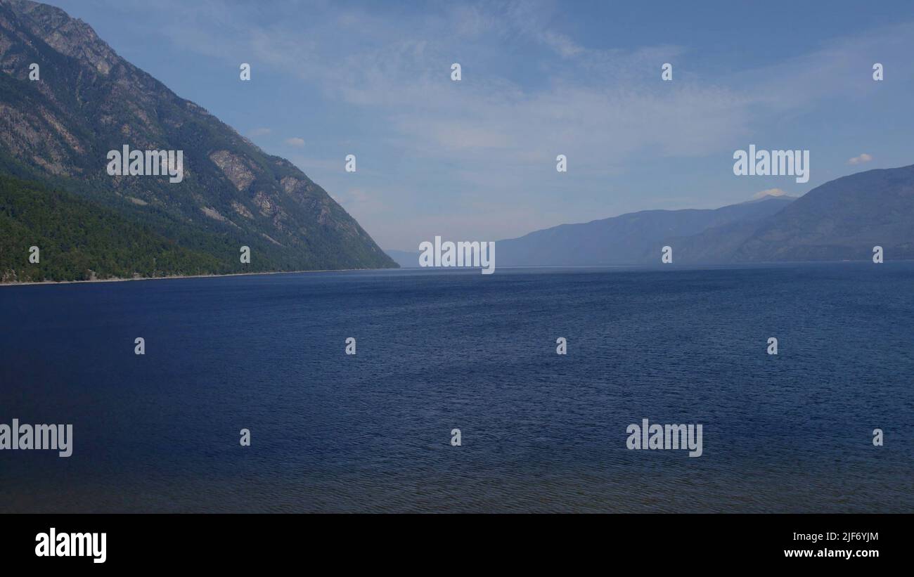 Lake Teletskoye between mountains with blue clear sky in Altai, Siberia ...