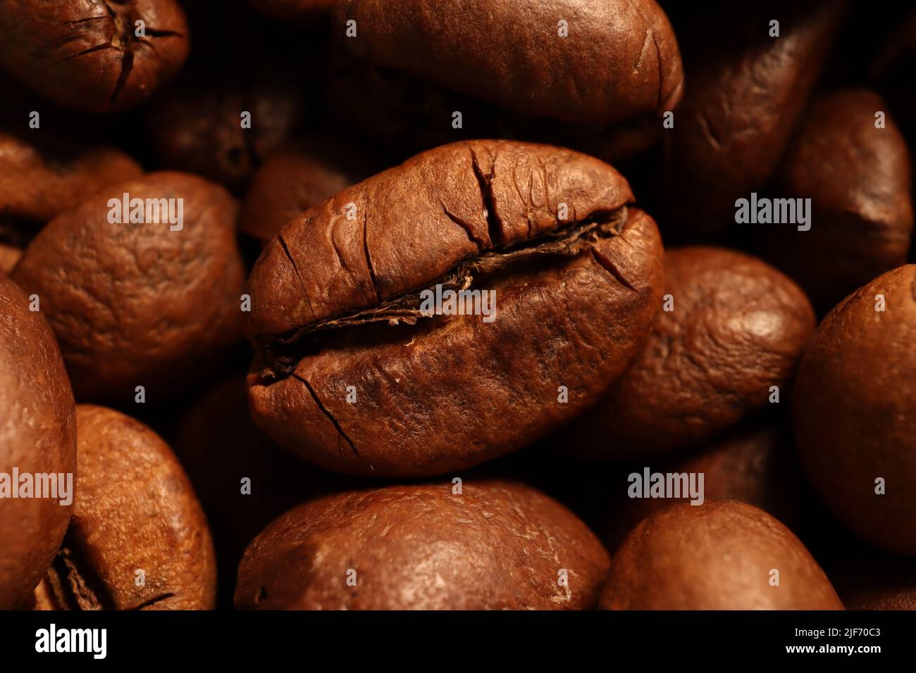 Coffee beans under warm light in close-up Stock Photo - Alamy