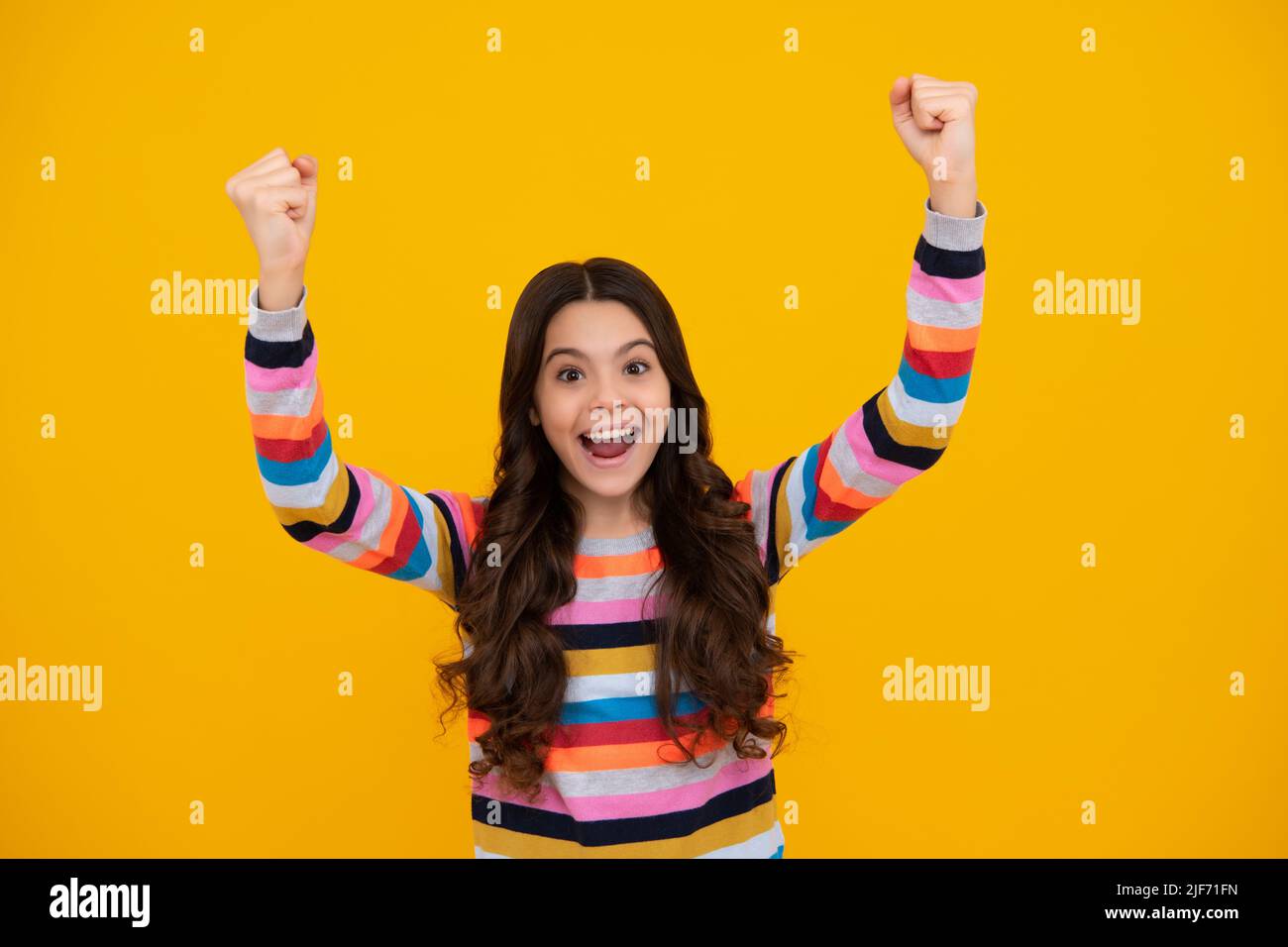 Amazed teenager. Studio portrait of teenager child doing winner gesture ...