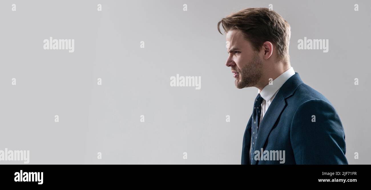 Angry business professional man stand sideway in anger grey background ...
