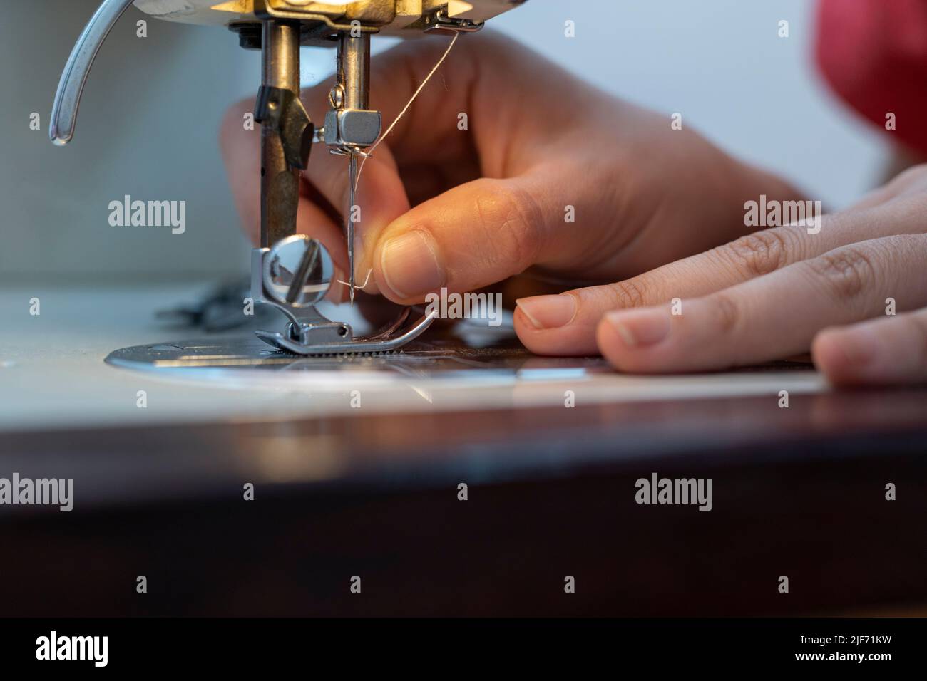 Female tailor's hands using a sewing machine Stock Photo - Alamy