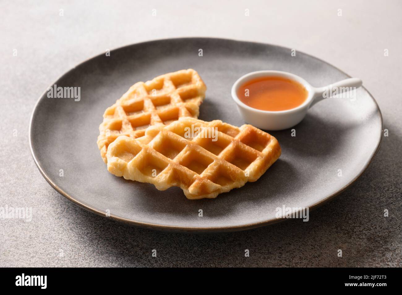 Trendy viral croffles in plate served maple syrup on gray background ...