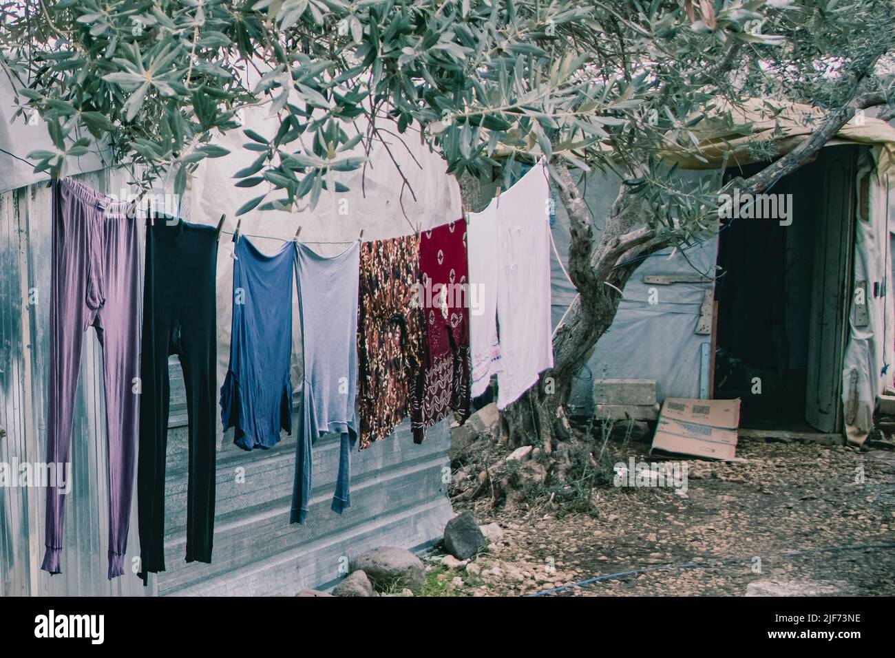 Clothes of a Syrian refugee family hanging on a rope to dry. Halba is ...