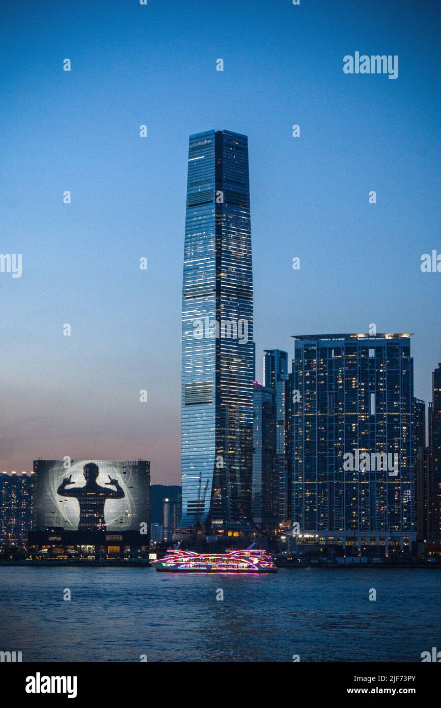 A vertical shot of ICC Tower near the water in Hong Kong at night Stock Photo - Alamy