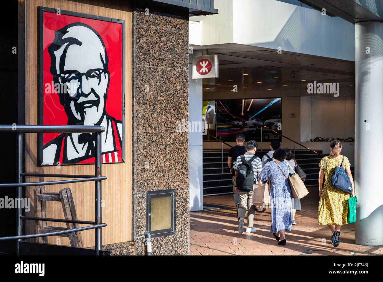 Pedestrians walk past an American fast food chicken restaurant chain ...