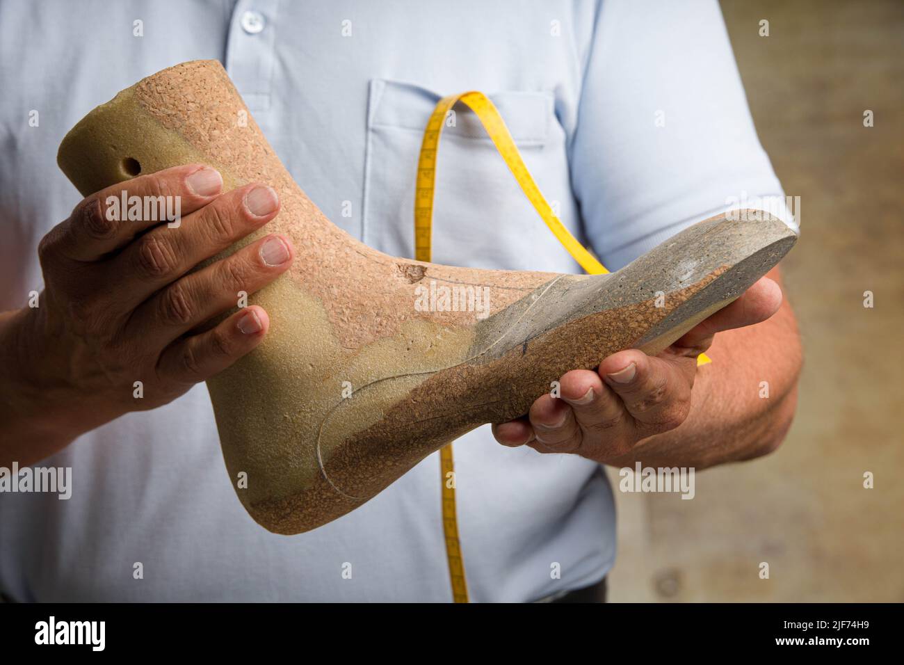 Close up of hands of an orthopedic shoemaker presenting an individual ...
