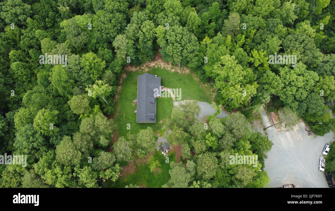 An aerial view of the house in the middle of a dense forest Stock Photo ...
