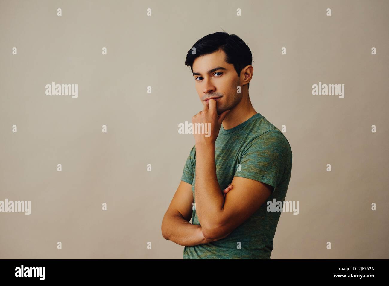 Portrait hispanic latino man with arms crossed hand on chin black hair ...