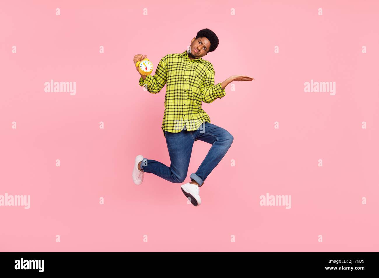 Full body photo of brown haired clueless man jump alarm clock hand ...