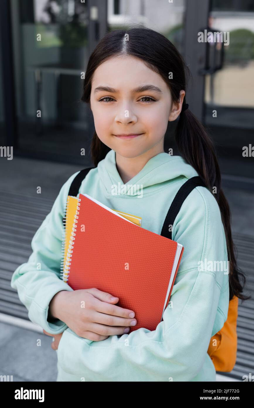 Portrait of schoolkid holding notebooks outdoors Stock Photo - Alamy