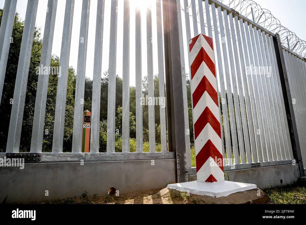 Polish border pole is seen against metal barrier and Belarusan border ...