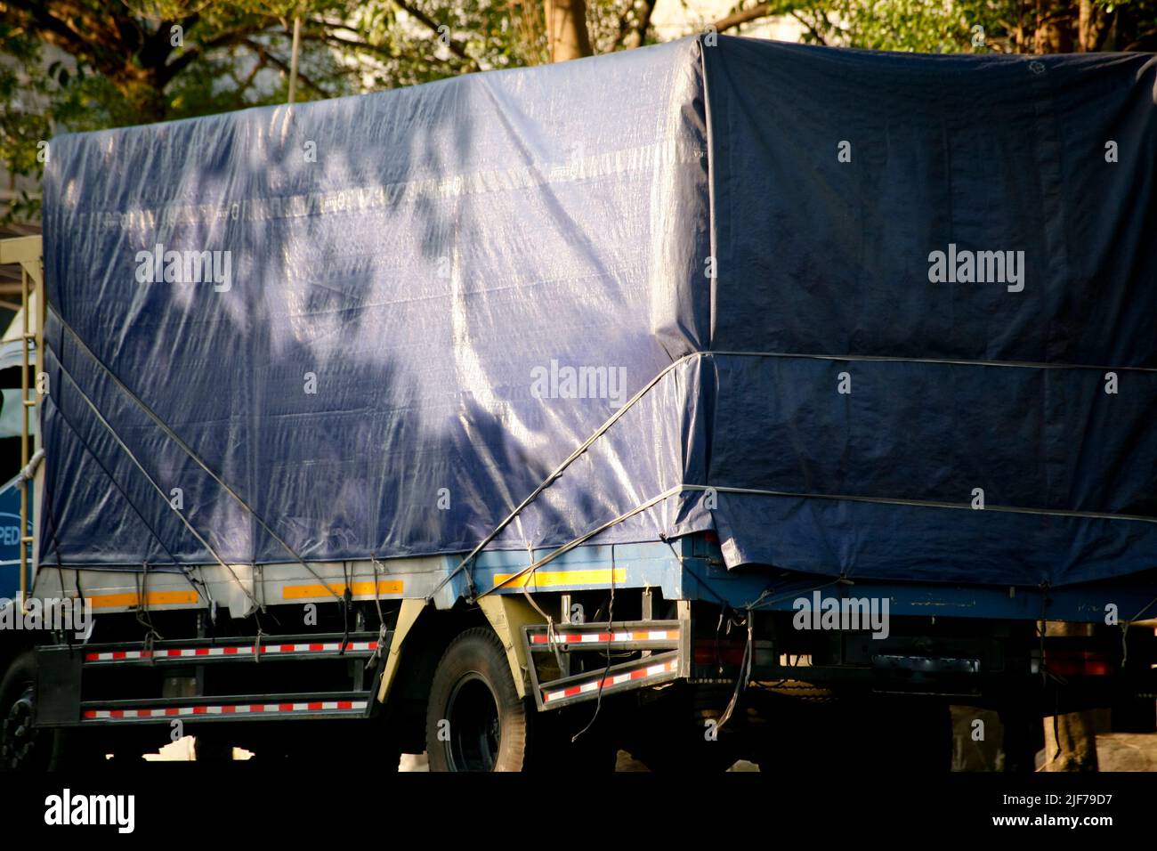 Side view of container truck covered with plastic sheeting Stock Photo ...