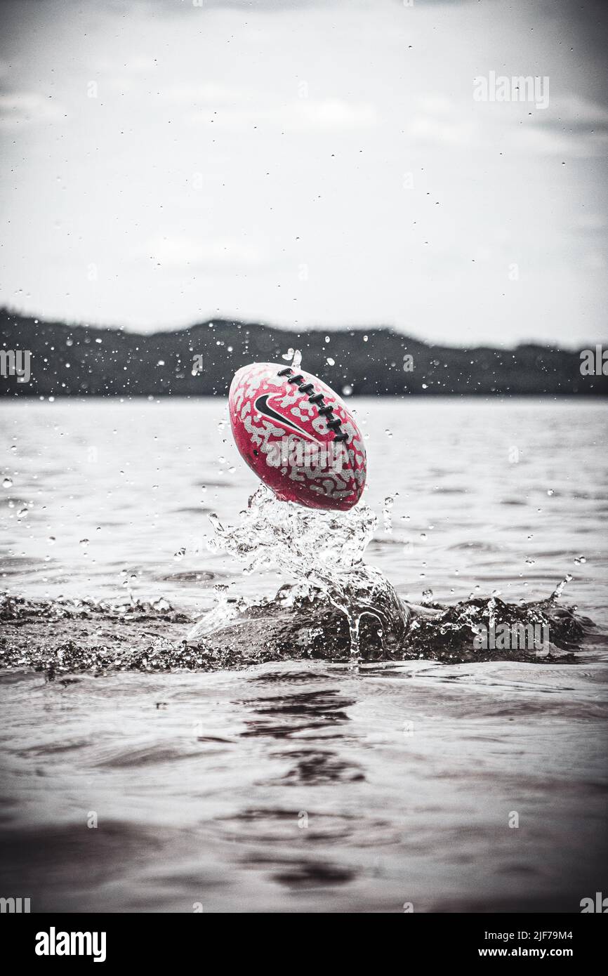 A vertical shot of the Nike rugby ball above the water surface Stock ...
