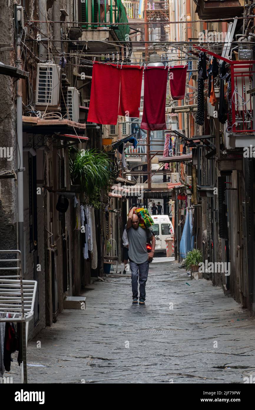 Naples, Italy. May 27, 2022. A man carrying a bag on a shoulder on the ...