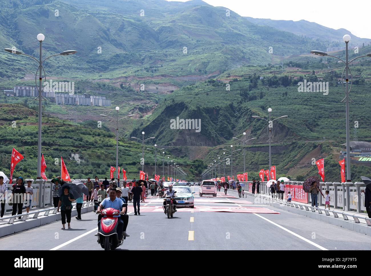 Jinyang, China's Sichuan Province. 30th June, 2022. People cross a ...