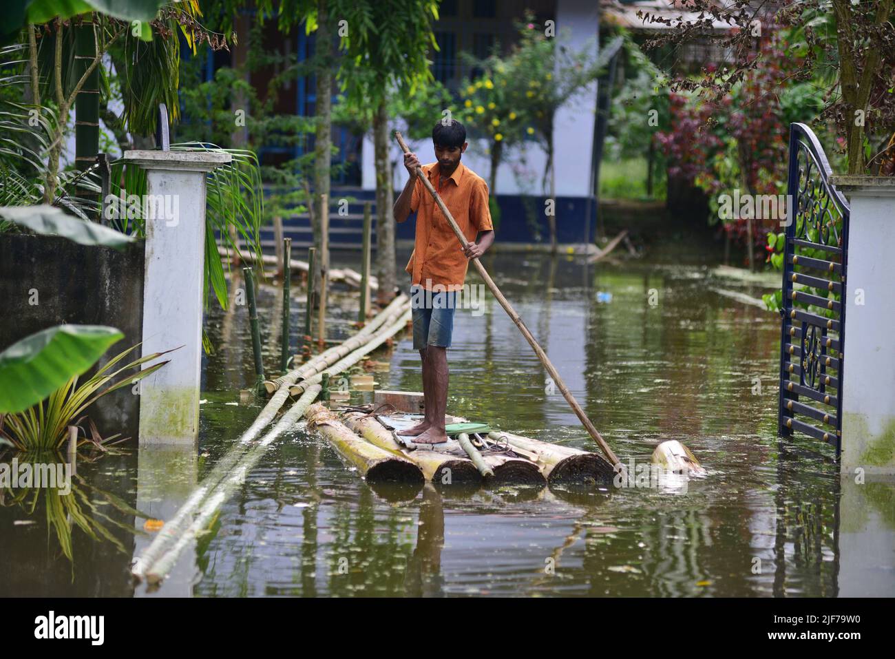 Nagaon. 30th June, 2022. A villager uses a makeshift raft through flood ...