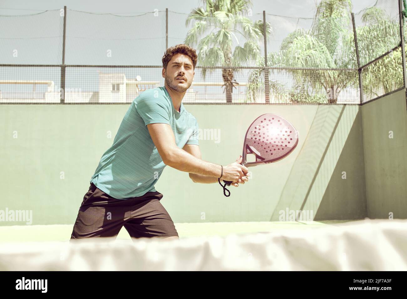 Padel player in position waiting for the ball. Coach and padel player ...