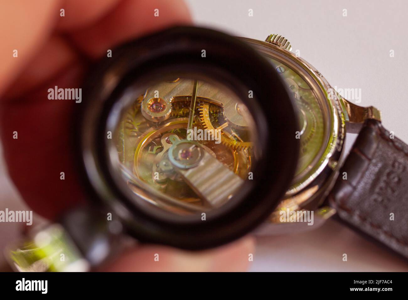 Inside og watch seen through magnifying glass at watchmaker. Close-up ...