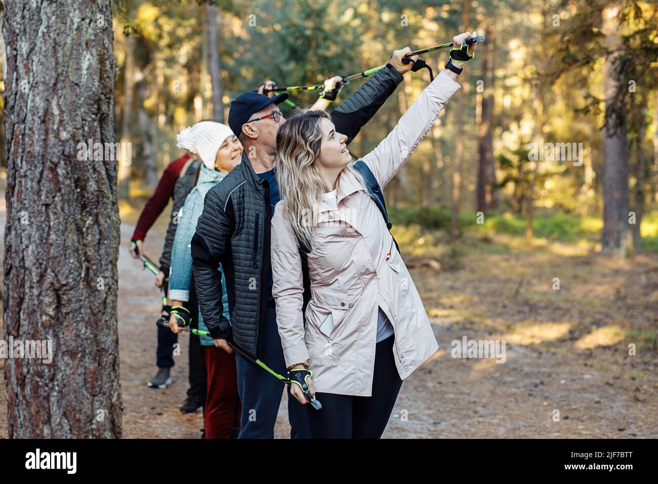 Group of people holding together Nordic trekking poles in the air on ...