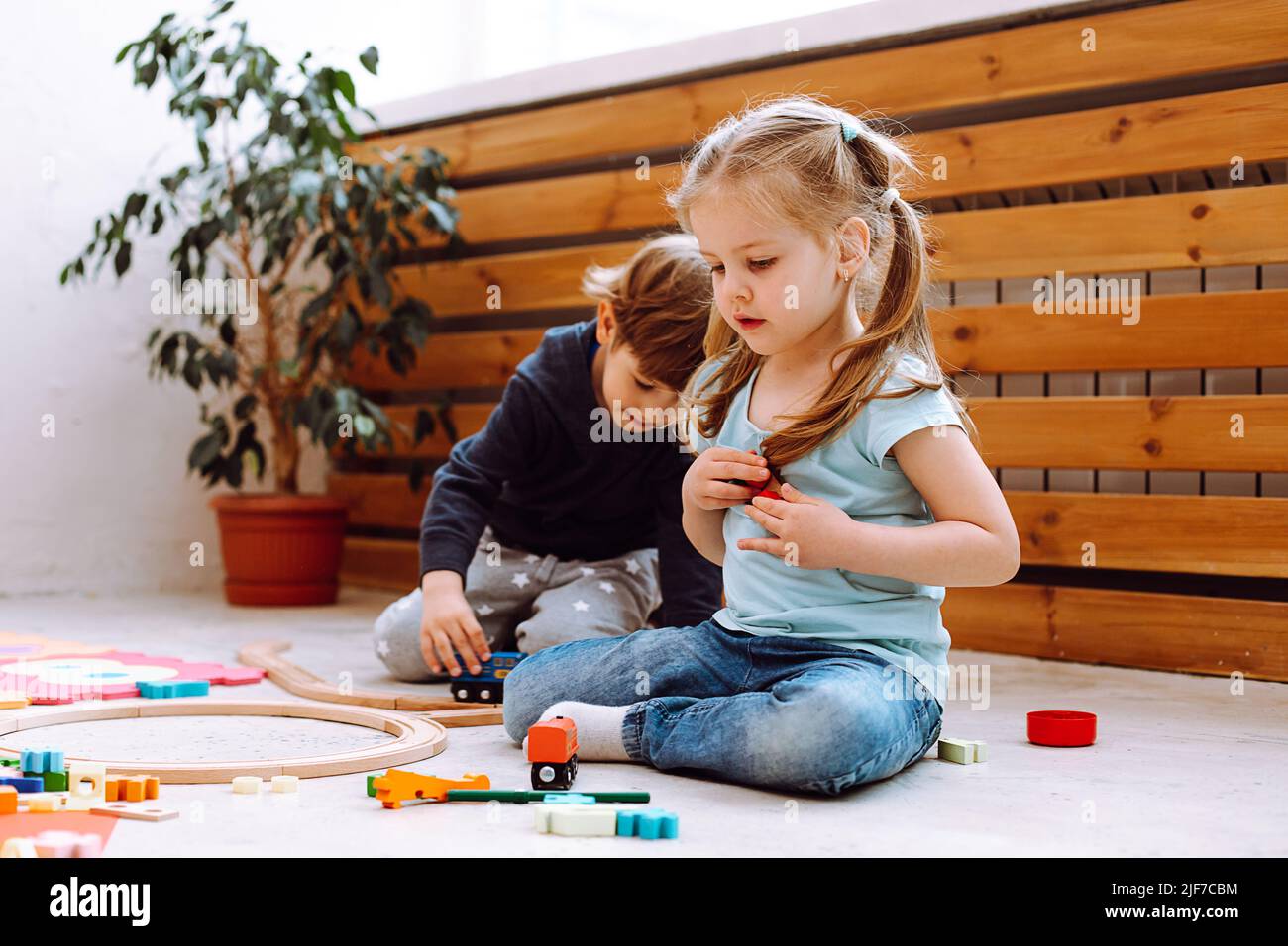 Little girl and boy sitting on floor and playing with constructor lego ...