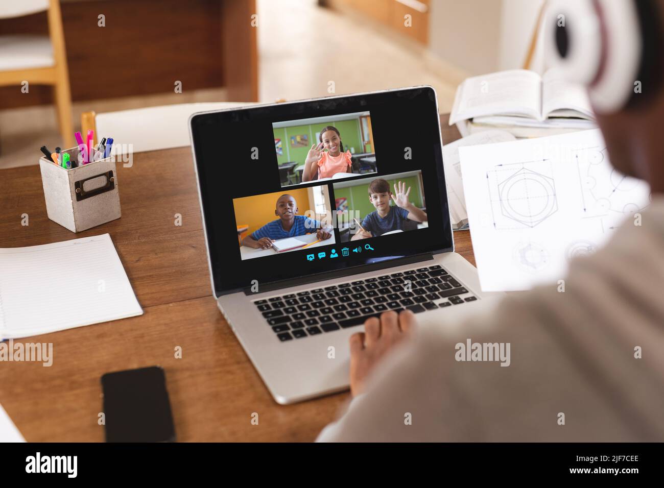 Multiracial boy looking at students on laptop screen while attending ...