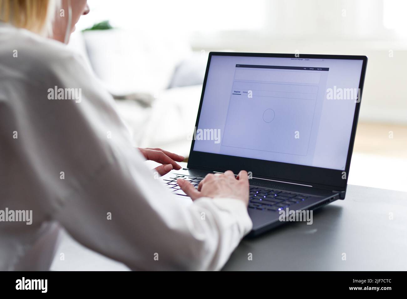 Laptop screen. Woman uses her notebook computer while sitting at desk ...