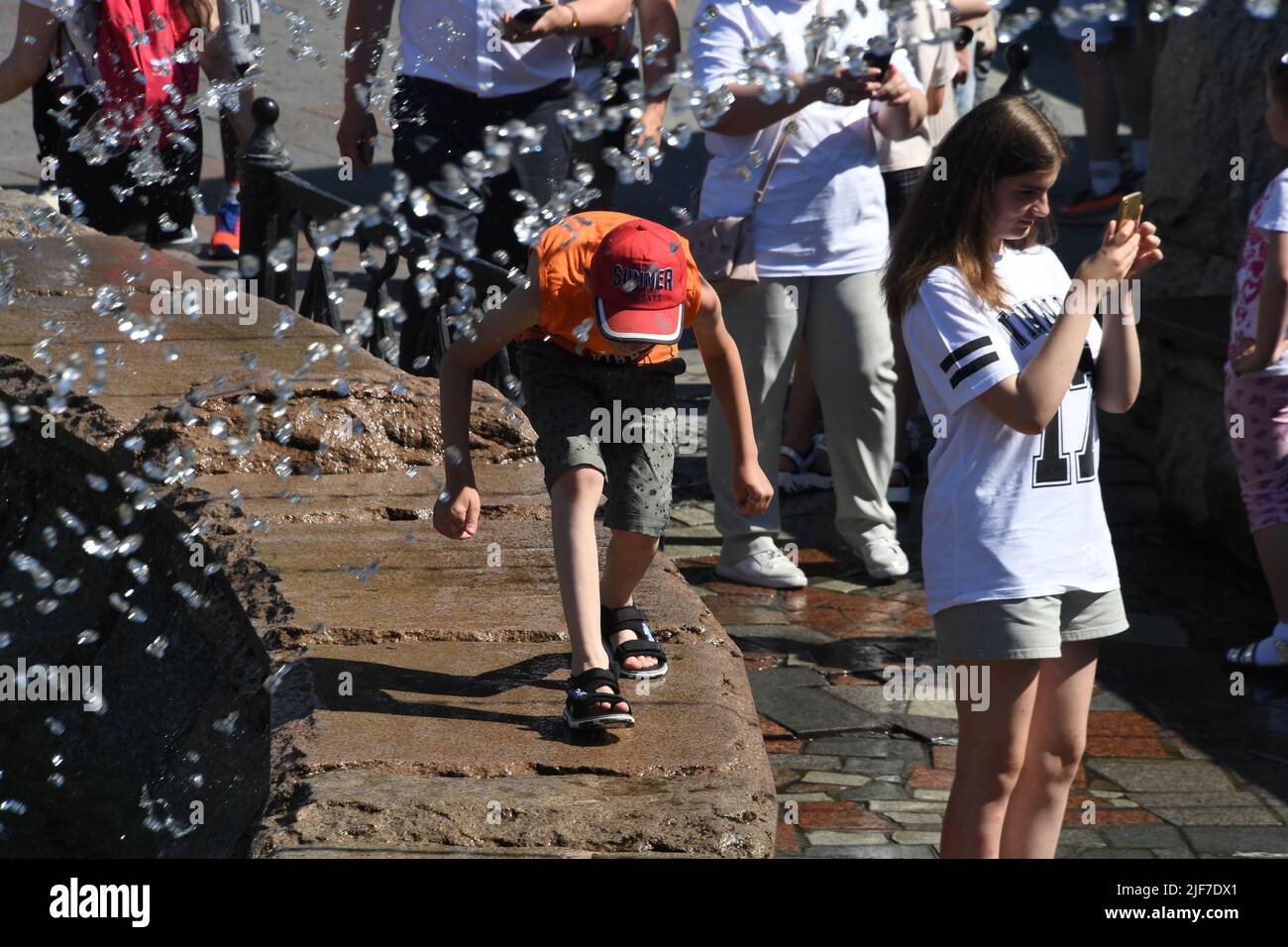 Moscow. Children at a fountain at Manezhnaya Square in hot weather ...