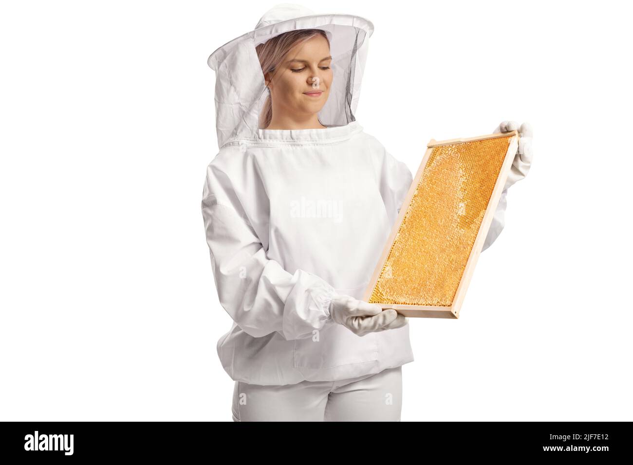 Young female bee keeper holding a honeycomb frame isolated on white ...