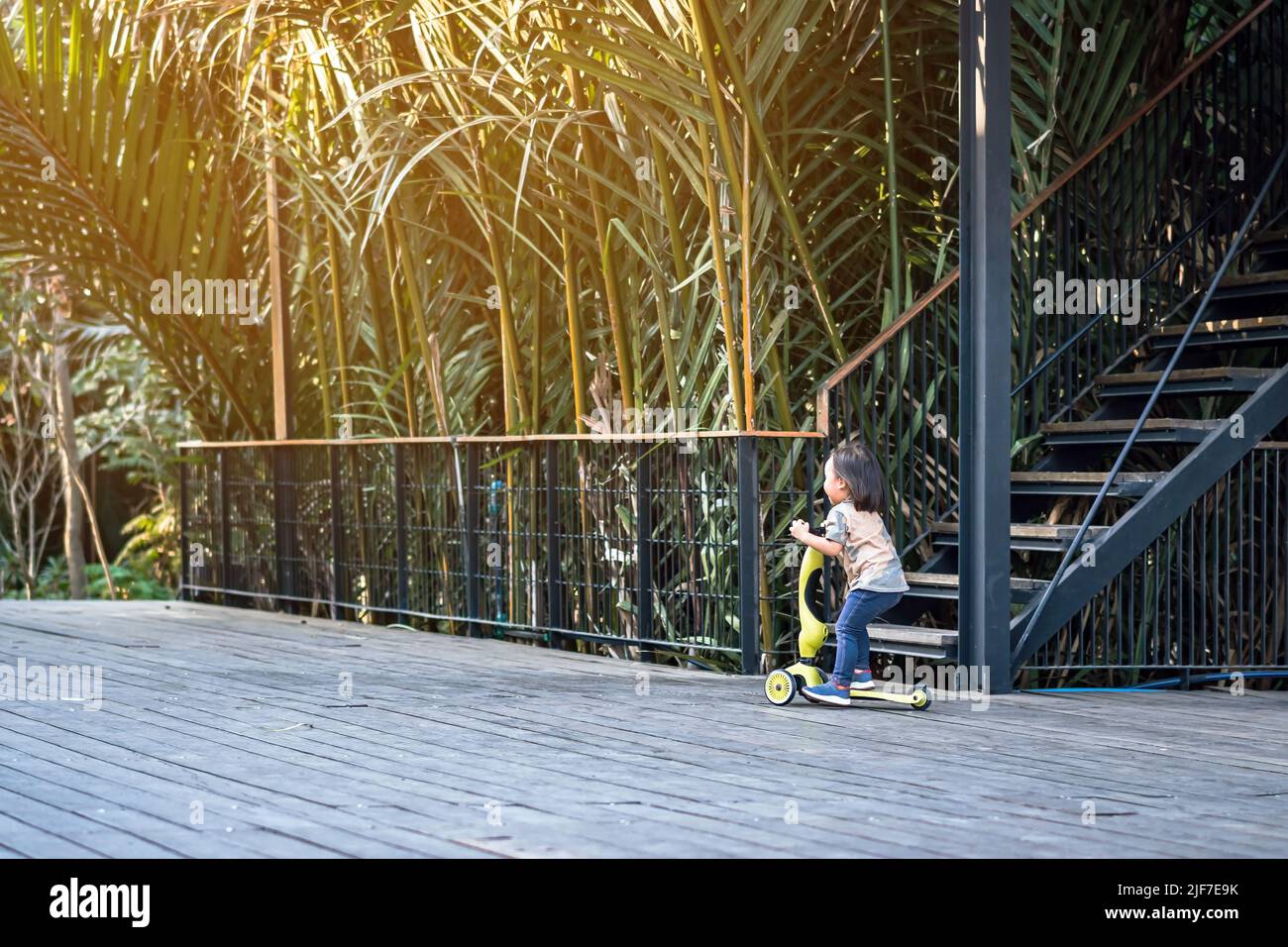 Asian kid enjoy playing and riding scooter without using any safety ...