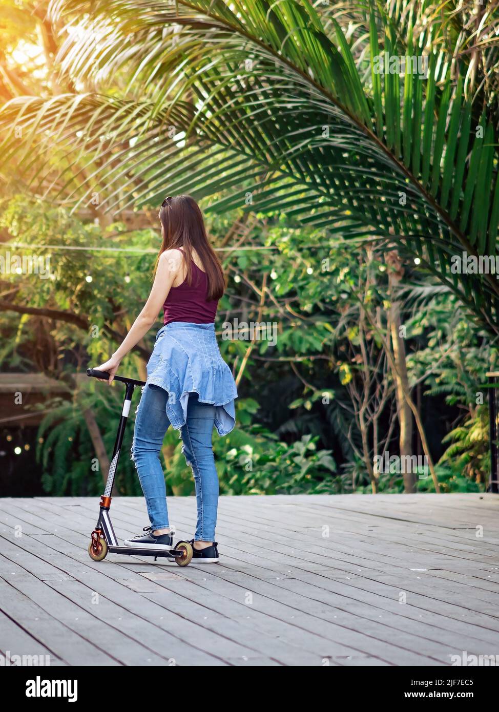 Asian woman enjoy playing and riding modern extreme stunt kick scooter ...