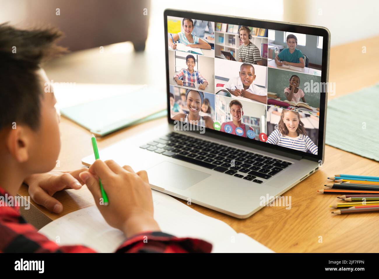 Asian focused boy looking at laptop screen with students during online ...