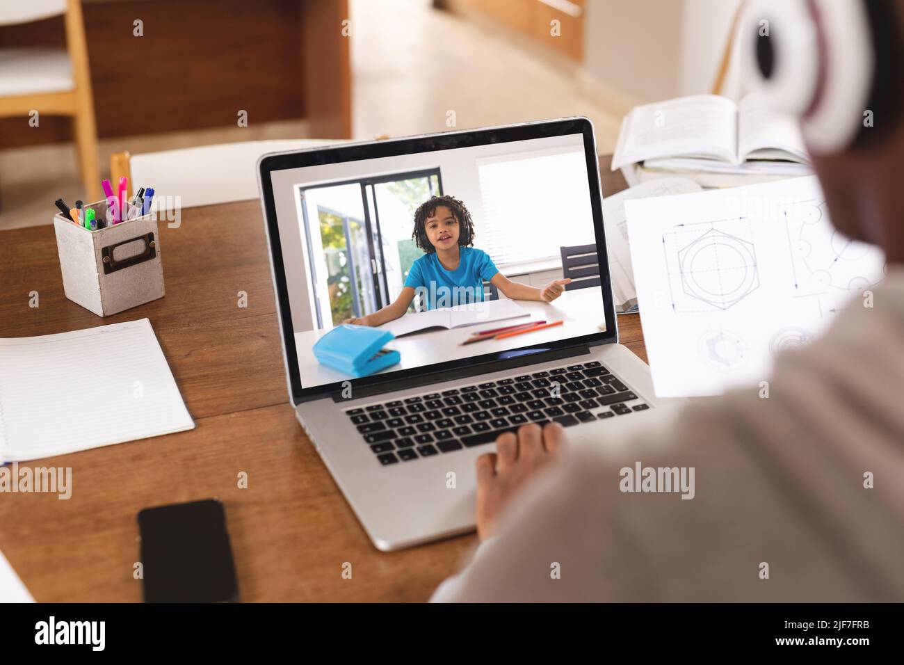 African american student discussing with friend over video call while ...