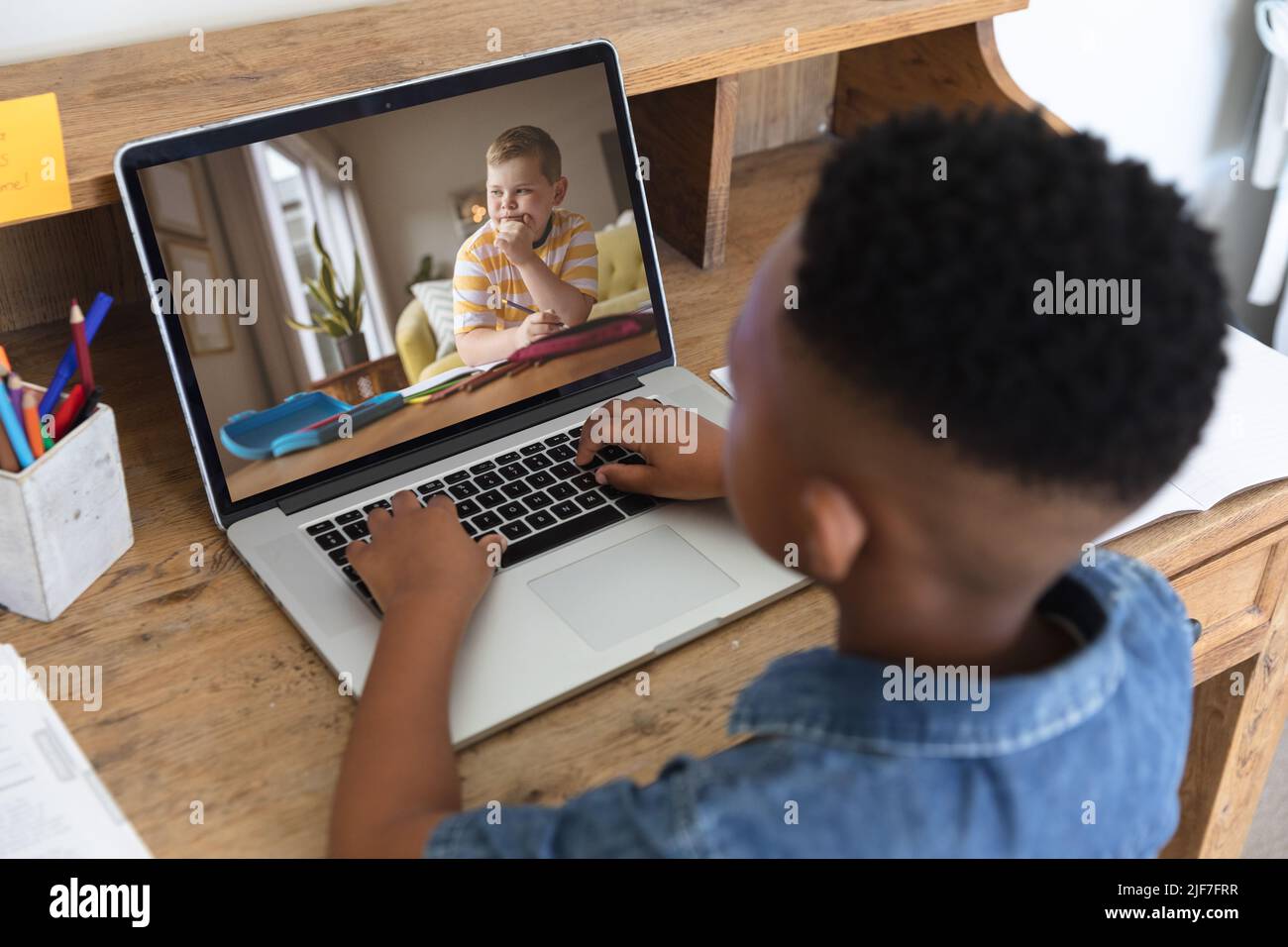 African american boy looking at caucasian student on laptop screen ...