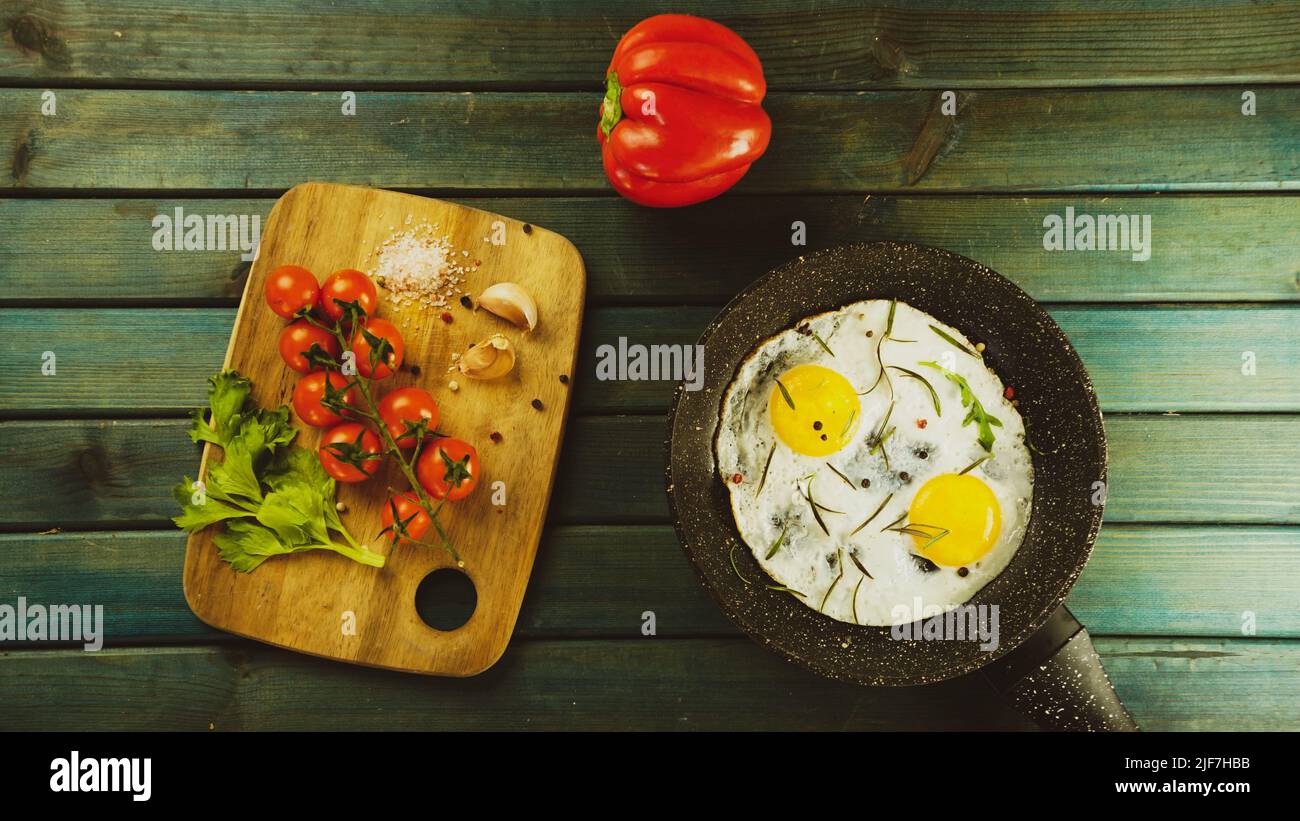 scrambled eggs fried eggs omelet with tomatoes and garlic in a rustic ...