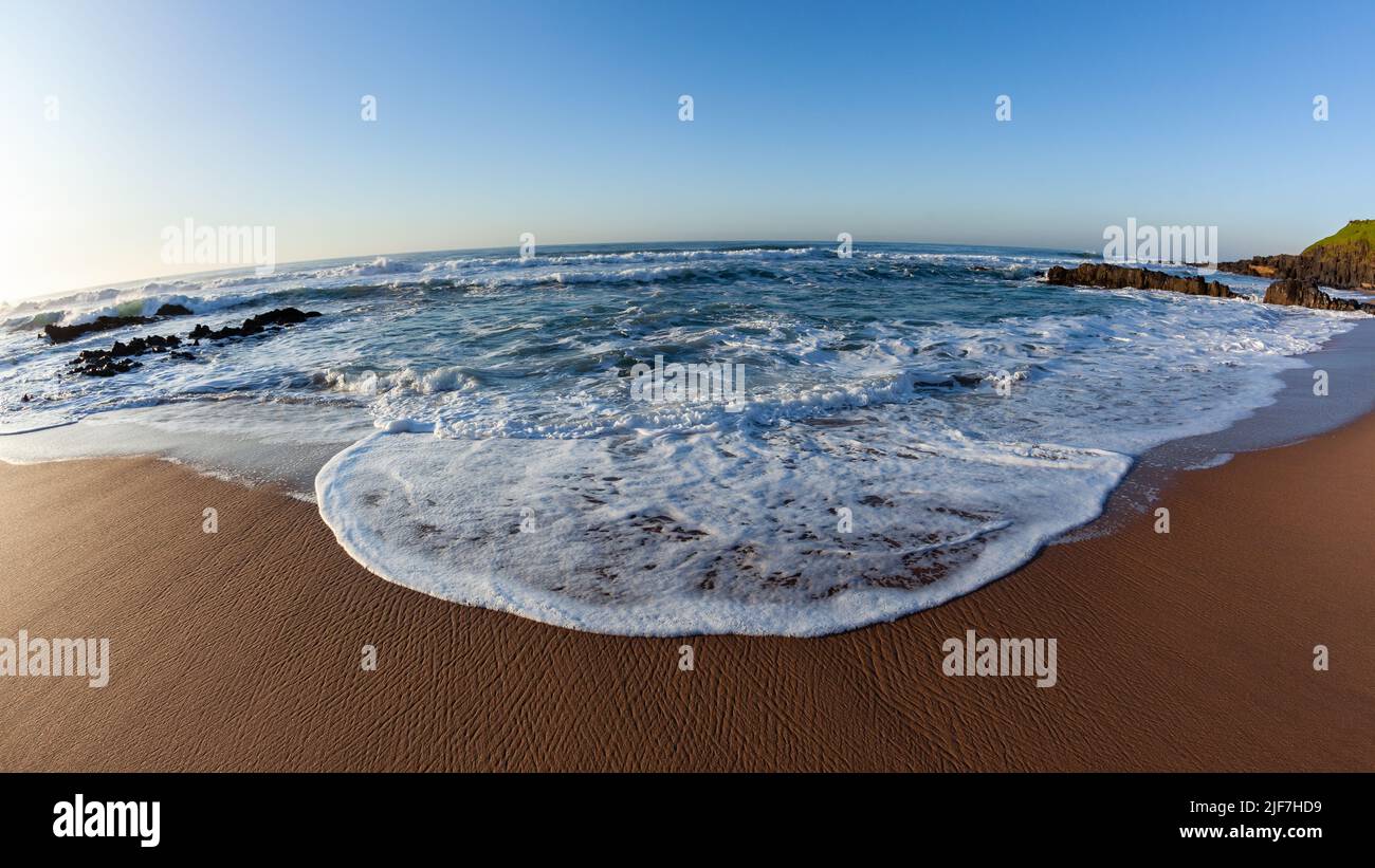 Beach sand waters edge wave wash rocky coastline morning scenic ocean ...