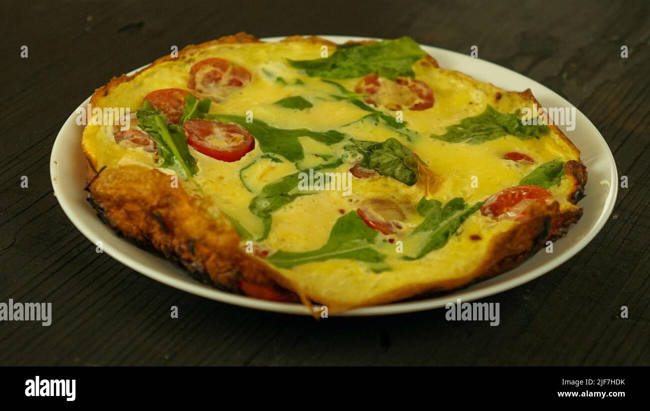 scrambled eggs fried eggs omelet with tomatoes and garlic in a rustic ...