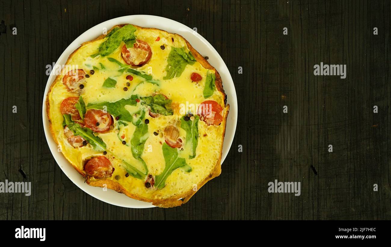 scrambled eggs fried eggs omelet with tomatoes and garlic in a rustic ...