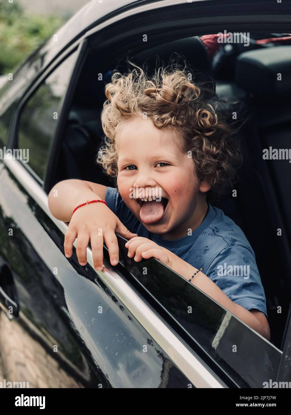 blond boy looking out of car window Stock Photo - Alamy
