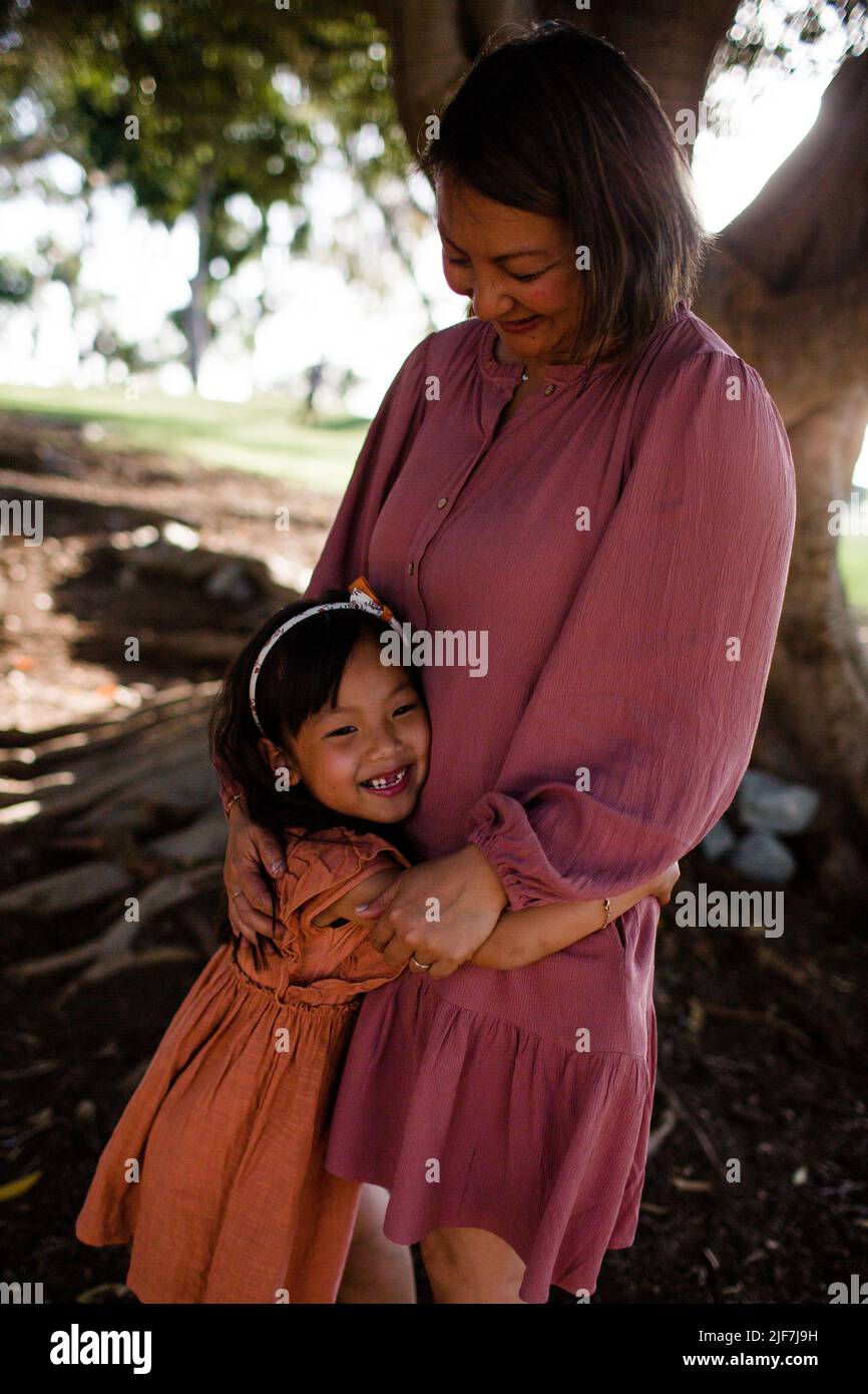 Mother & Daughter Hugging Under Tree at Park in San Diego Stock Photo ...