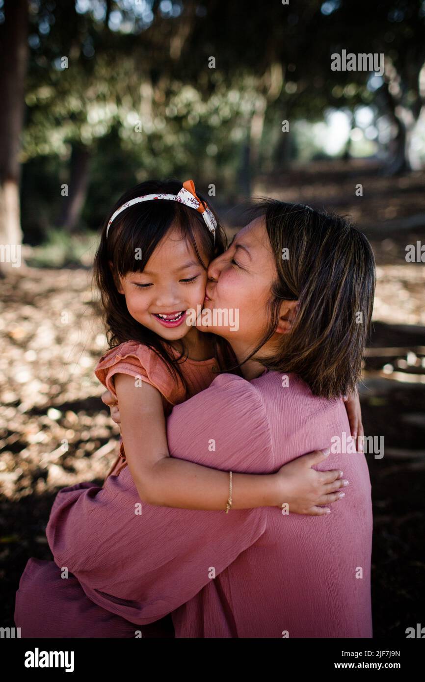 Asian daughter hugging kissing mother hi-res stock photography and images - Alamy