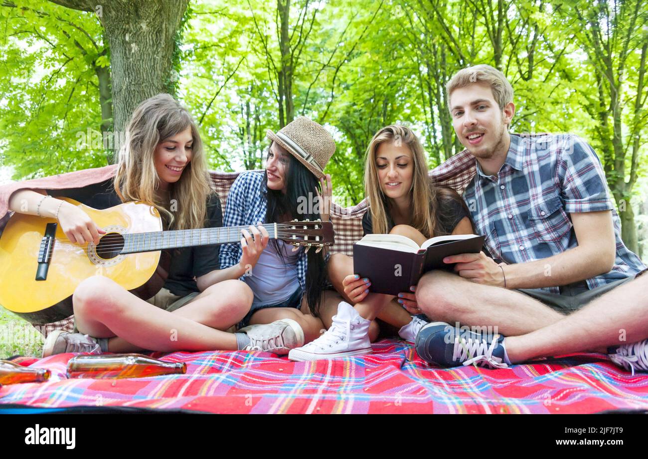 young adults have fun with guitar at the campground Stock Photo - Alamy