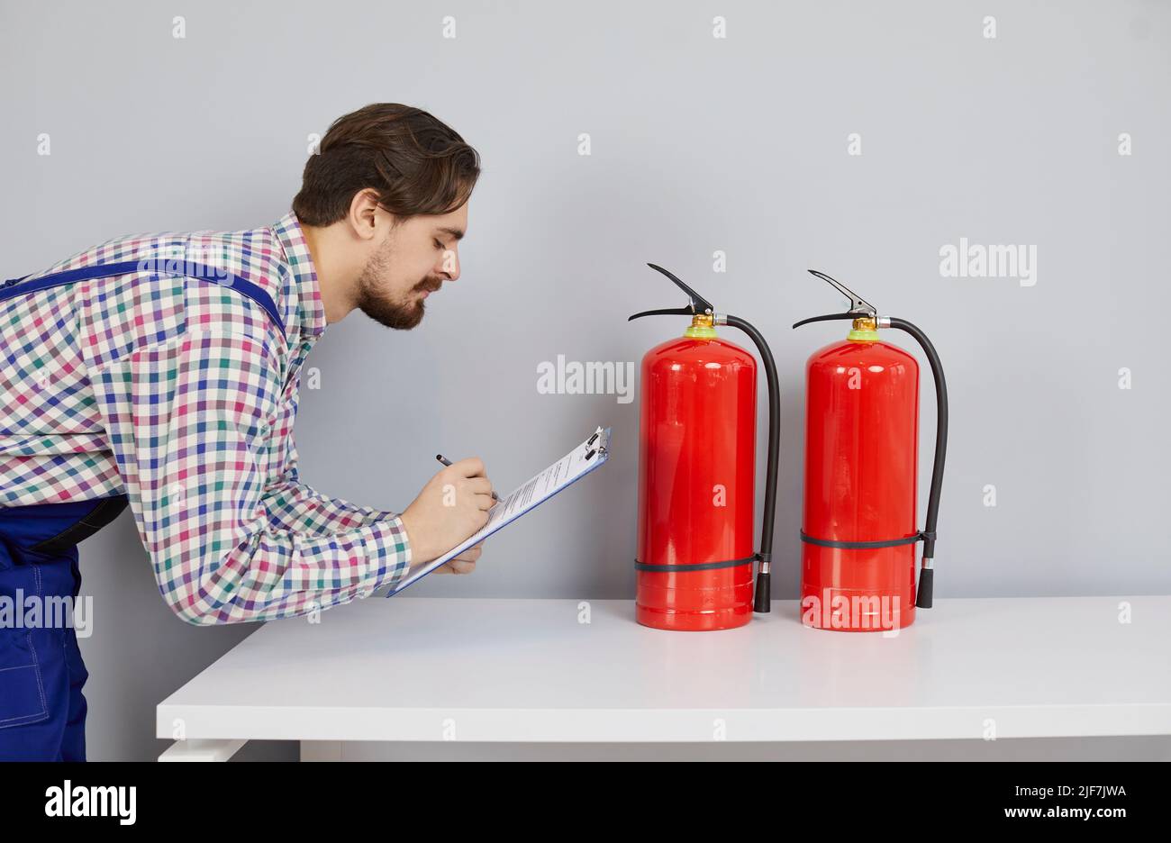 Male mechanic check fire extinguisher balloon Stock Photo - Alamy