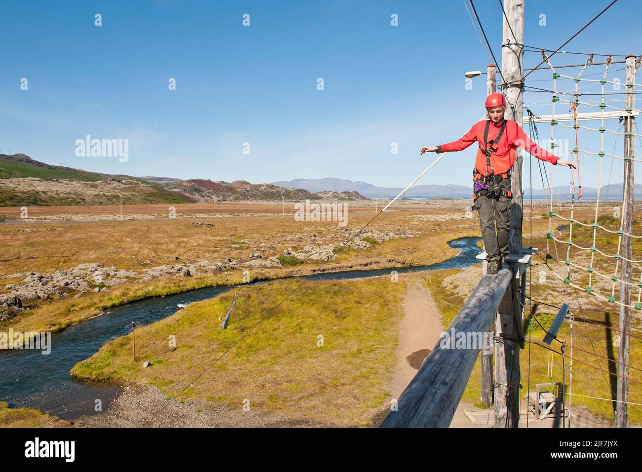 teenage boy balance on plank at high rope playground in Iceland Stock ...