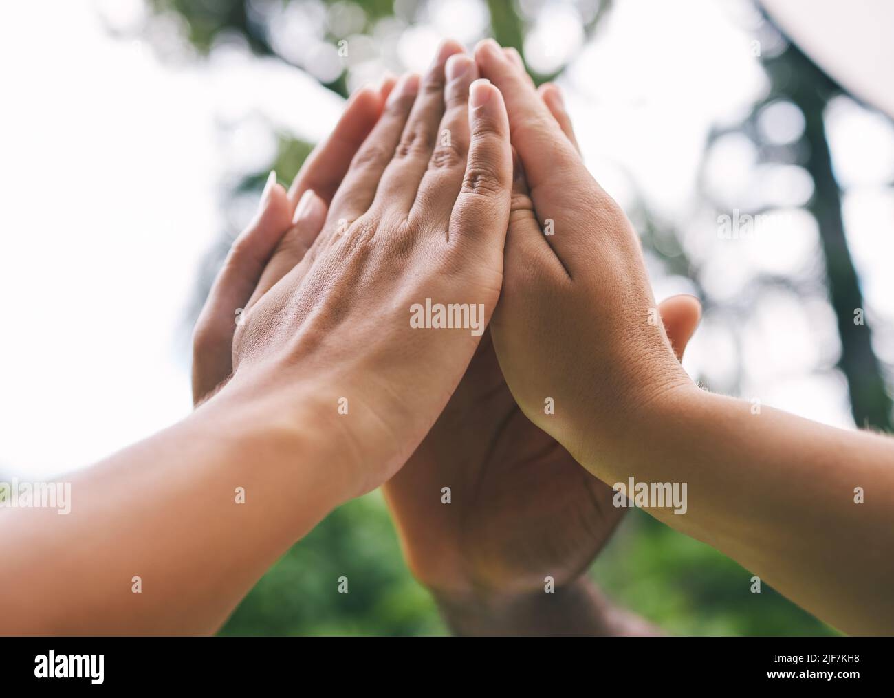 High fives of a diverse group of people. Closeup of multiethnic hands ...