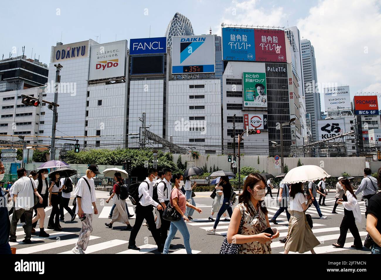 Tokyo, Japan. 30th June, 2022. Pedestrians wearing face masks shade ...